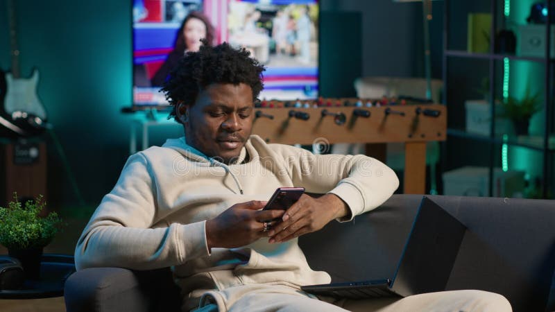 Relaxed African American Freelancer Smiling while Browsing His ... Relaxed African American Freelancer Smiling while Browsing His ...