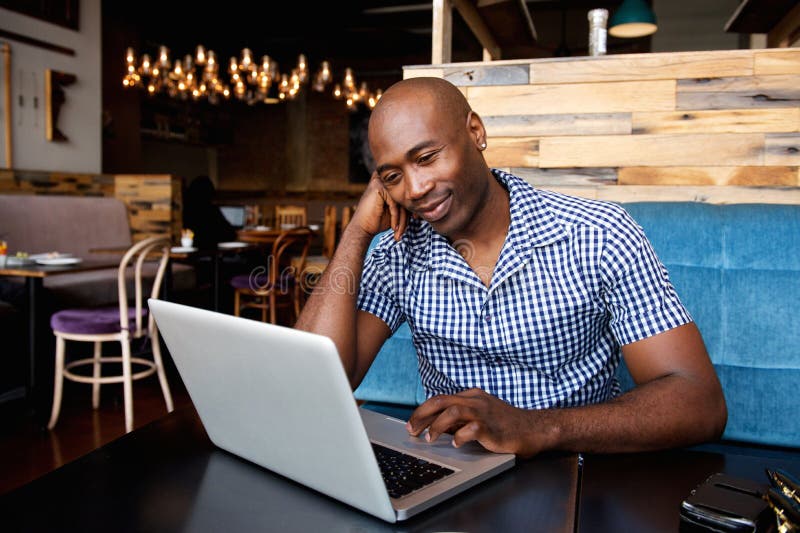 Relaxed African Man at a Cafe Table Using Laptop Stock Photo - Image of ...