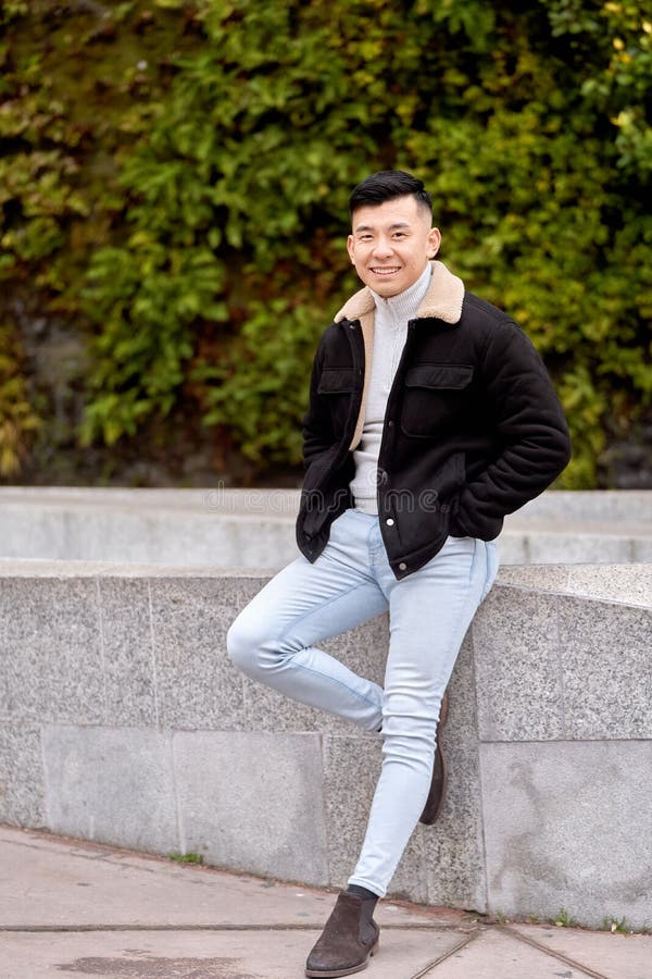 Relaxed Asian Man Looking at Camera and Smiling while Posing Outdoors ...