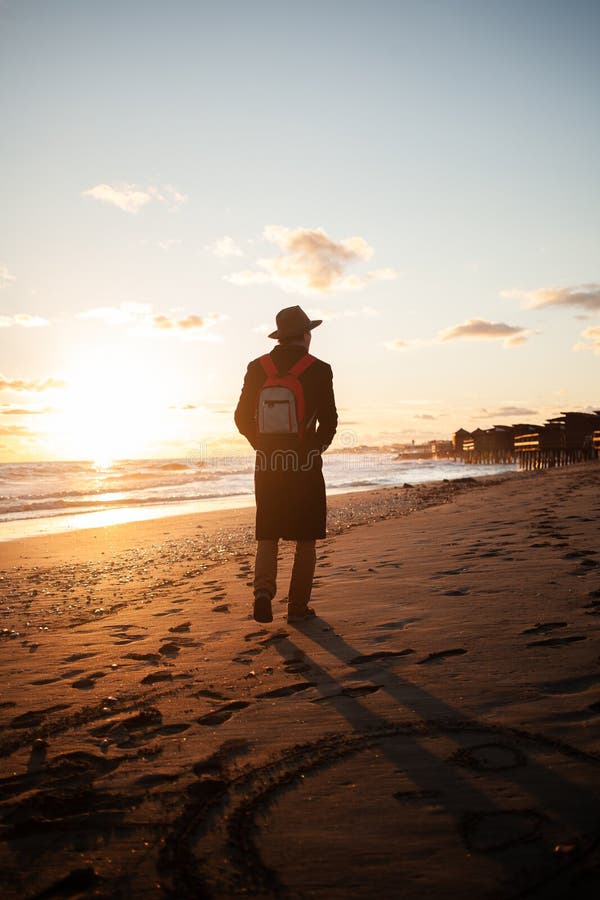 Relaxed Atmosphere As Man Strolls Beach at Twilight. Stock Image ...