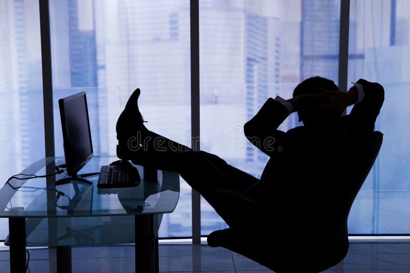 Relaxed Businessman Sitting at Computer Desk in Office Stock Photo ...