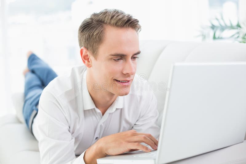Relaxed Casual Man Using Laptop while Lying on Sofa Stock Image - Image ...