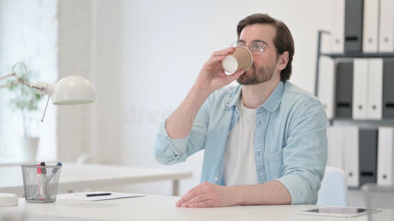 Relaxed Young Man Drinking Coffee at Work Stock Photo - Image of liquid ...