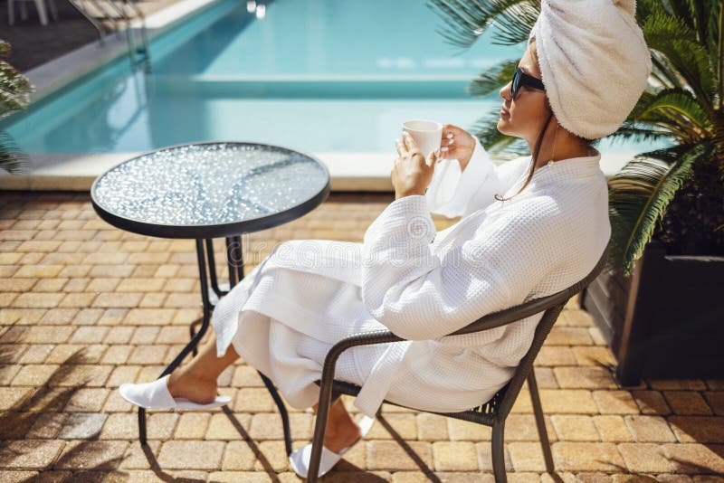 Relaxed Caucasian Female In Sunglasses And A Towel On Her Head Sits At