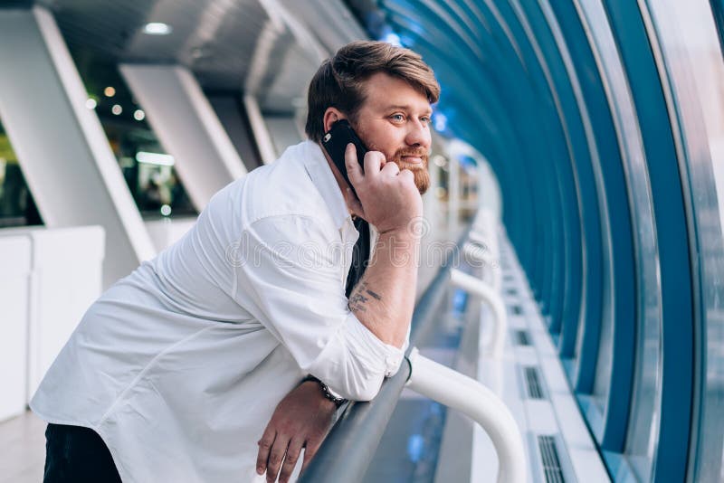 Relaxed Man Leaning on on Handrail and Talking Smartphone in Light ...