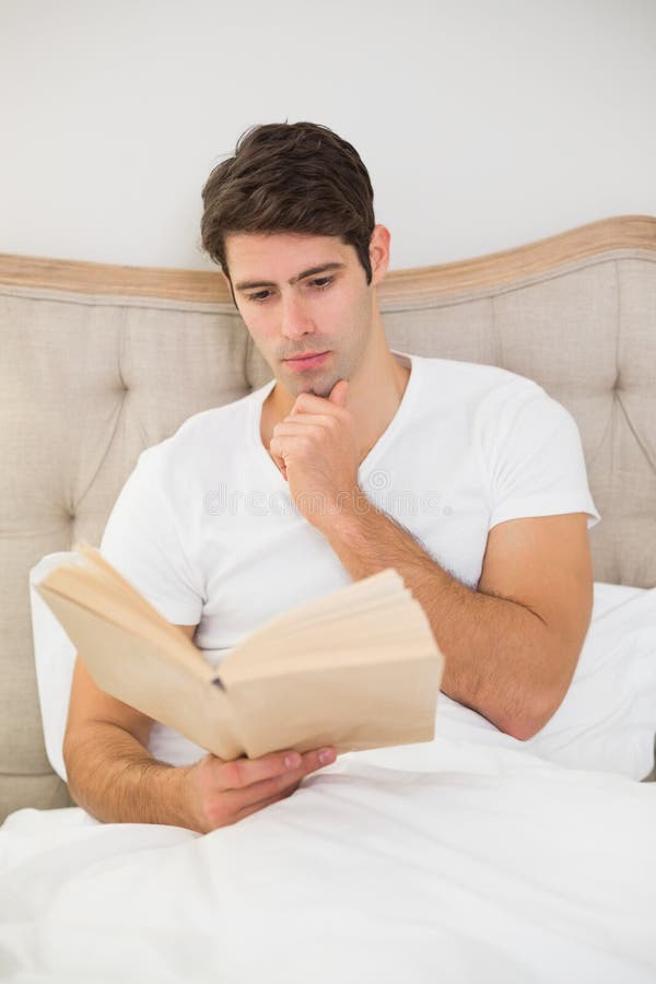 Relaxed Man Reading Book in Bed Stock Photo - Image of person, sitting ...
