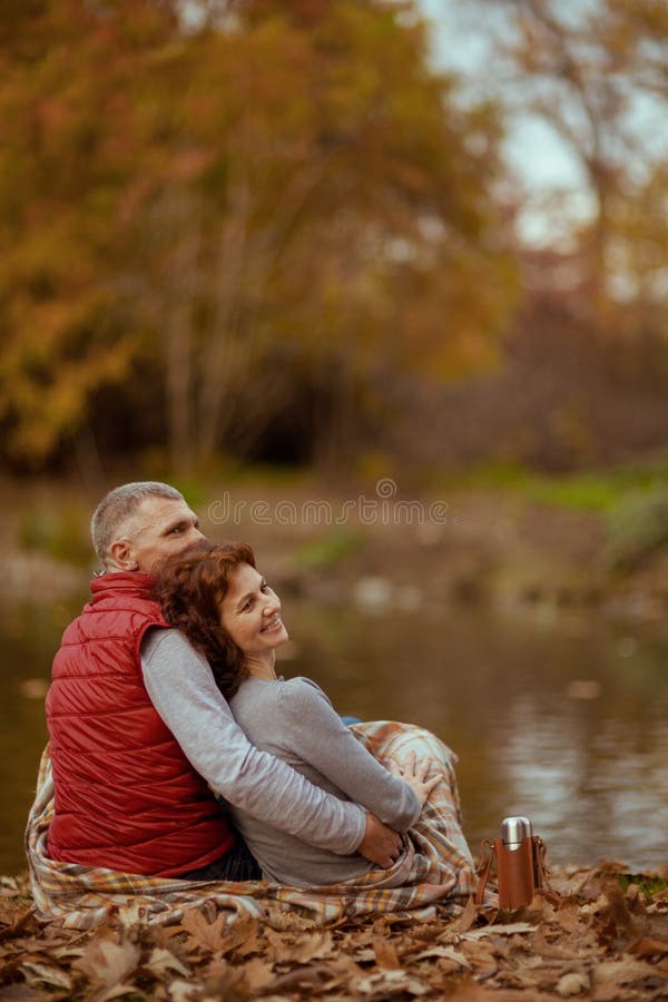 Relaxed Modern Couple in Park with Thermos Hugging Stock Photo - Image ...