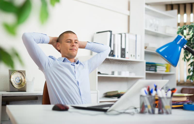 Relaxed Office Worker Sitting at Workplace with Hands Behind Head Stock ...