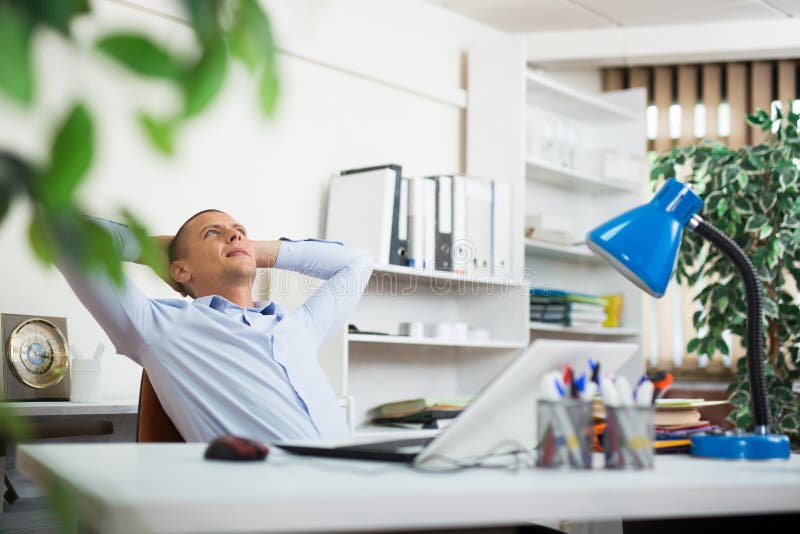 Relaxed Office Worker Sitting at Workplace with Hands Behind Head Stock ...