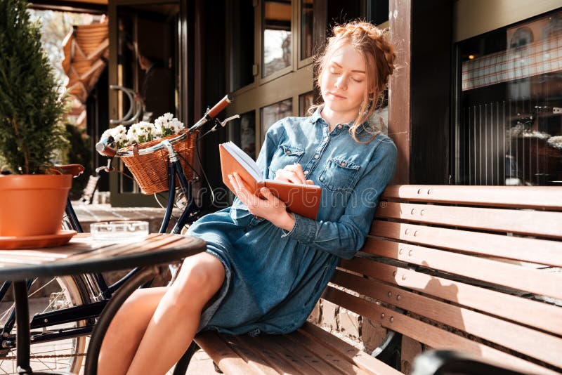 Relaxed Woman Sitting on Bench and Writing in Notebook Stock Photo ...