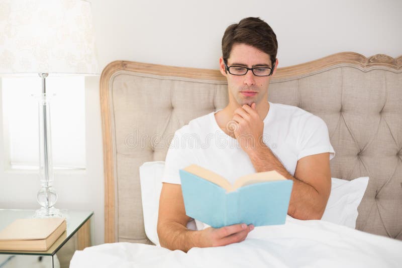 Relaxed Young Man Reading Book in Bed Stock Image - Image of lifestyle ...