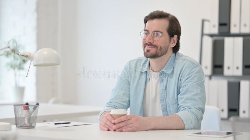 Relaxed Young Man Sitting at Work Stock Photo - Image of business ...
