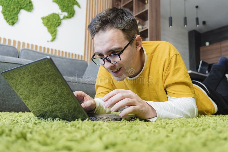Relaxed Young Man Using a Laptop on Floor at Home. Stock Photo - Image ...
