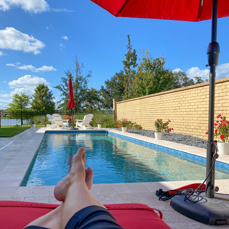 A Relaxing Backyard Swimming Pool with Red Umbrellas Stock Image ...