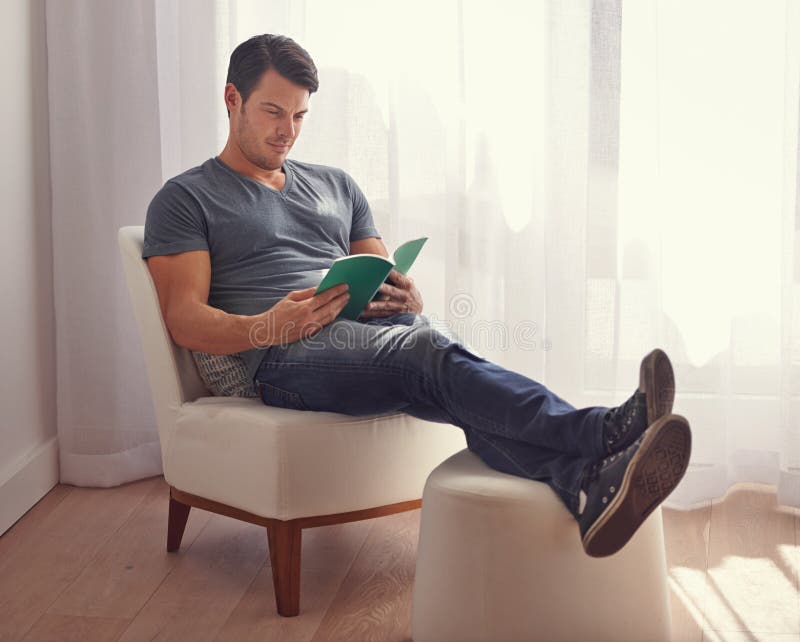 Relaxing with a Good Book. a Handsome Young Man Relaxing with a Book at ...