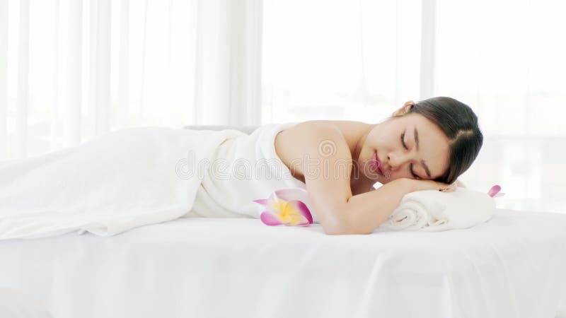 Relaxing Young Woman Lying Down And Closed Her Eyes On Massage Beds At