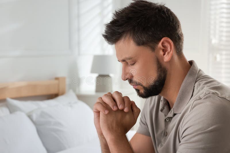 Religious Man Praying in Bedroom. Space for Text Stock Photo - Image of ...