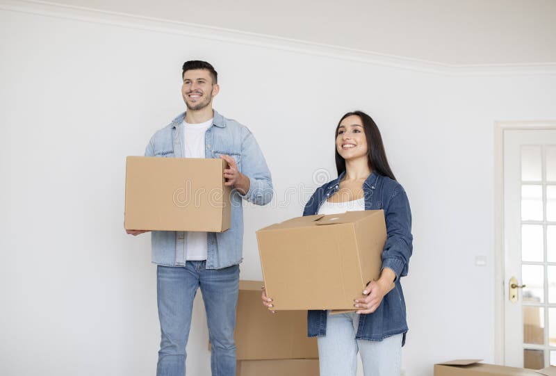 Relocation Concept. Happy Young Spouses Walking with Cardboard Boxes in ...
