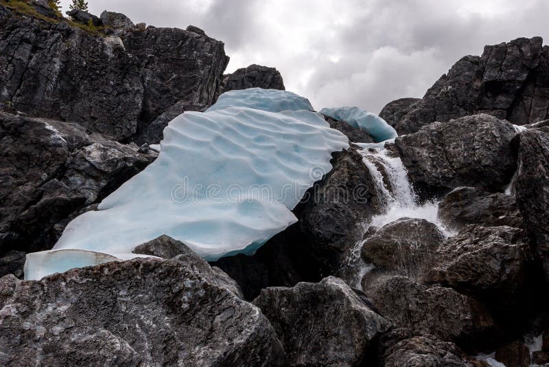 Remains of Old Ice on Stones through Which Water Flows. Stock Image ...