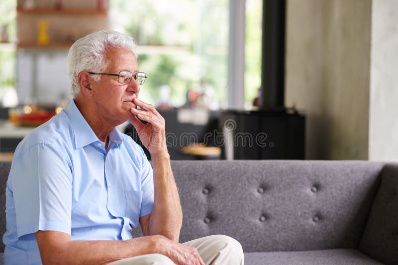 Remembering...a Thoughtful Looking Senior Man Sitting on His Sofa ...