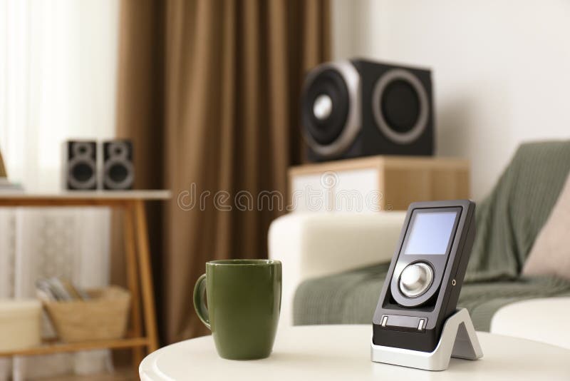 Remote Control of Audio Speaker System and Cup on White Table Indoors ...