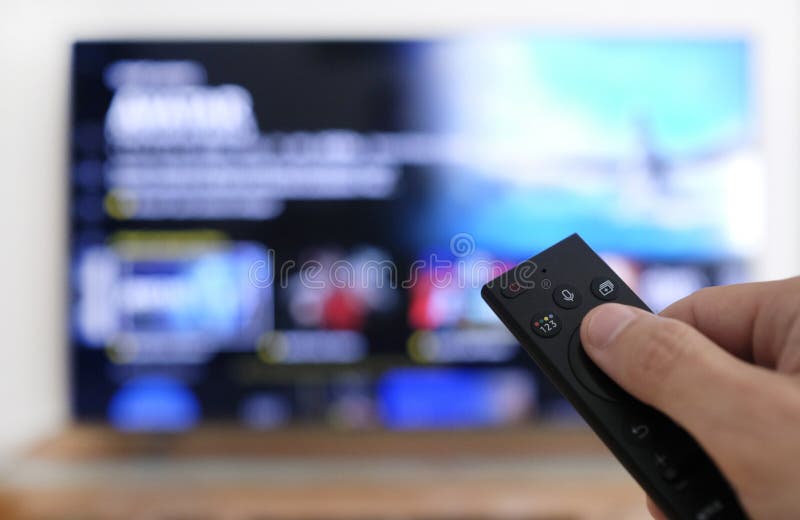 Hand Holding Remote Control and Screen in the Background Stock Image ...