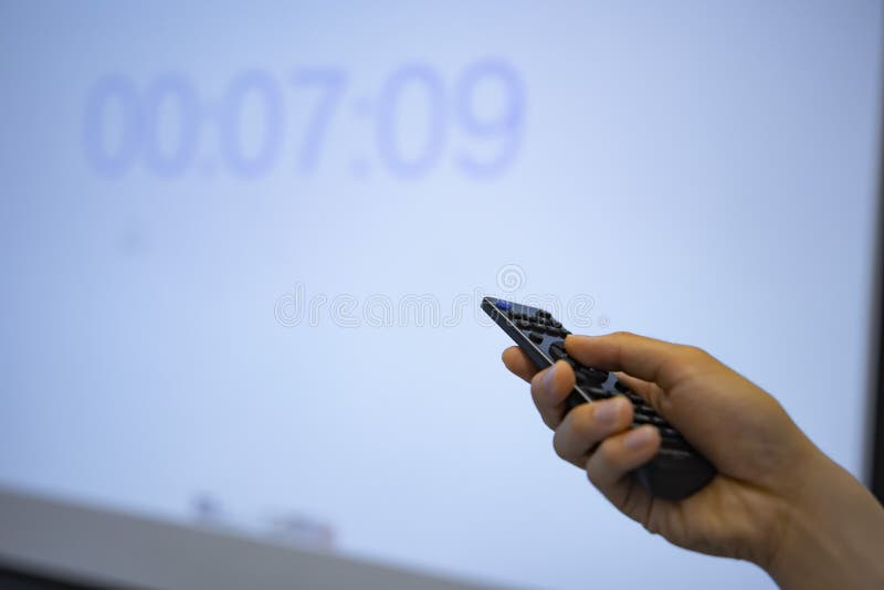 A Remote Controller with Right Hand Behind the White Board at the ...