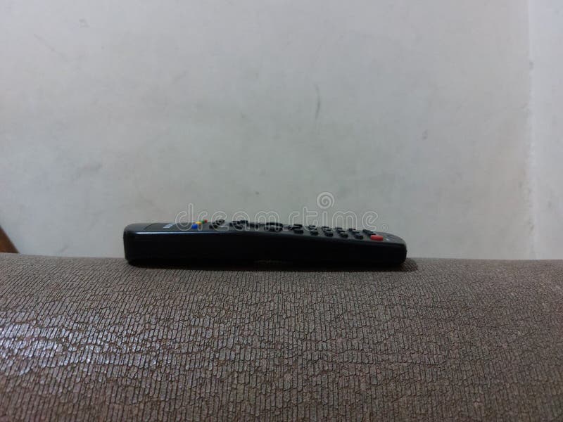 Remote TV on the couch stock photo. Image of movie, display - 287364910