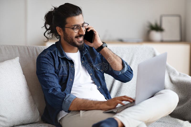 Remote Work. Freelancer Guy Using Laptop and Having Phone Conversation ...