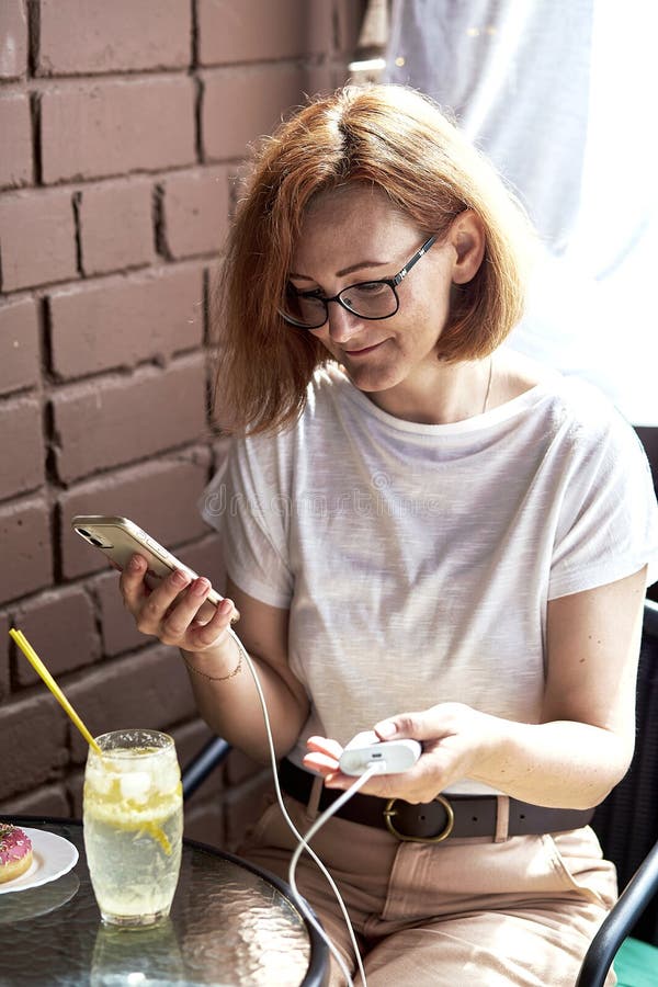 Remote Work a Freelancer Multitasks with Her Phone and Powerbank in a ...