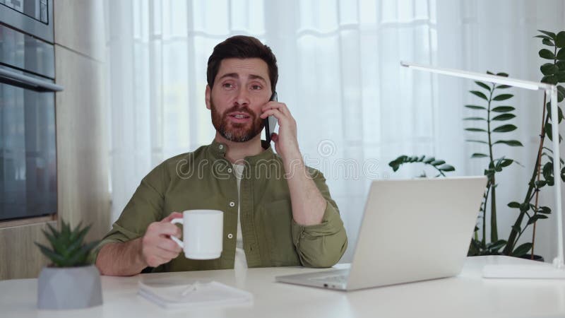 Remote Worker Communicating Via Mobile Phone on Coffee Break at Desktop ...