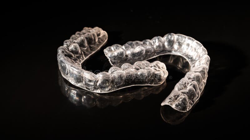 Removable Plastic Retainers for Bite Correction on a Black Background ...