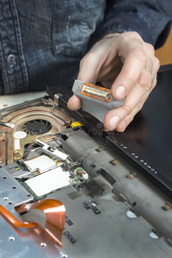 Removing the Laptop Casing. the Serviceman Holds a Computer Tape Stock ...
