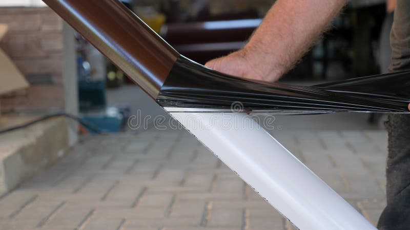 Removing the Protective Film from the New Gutter before Installation ...