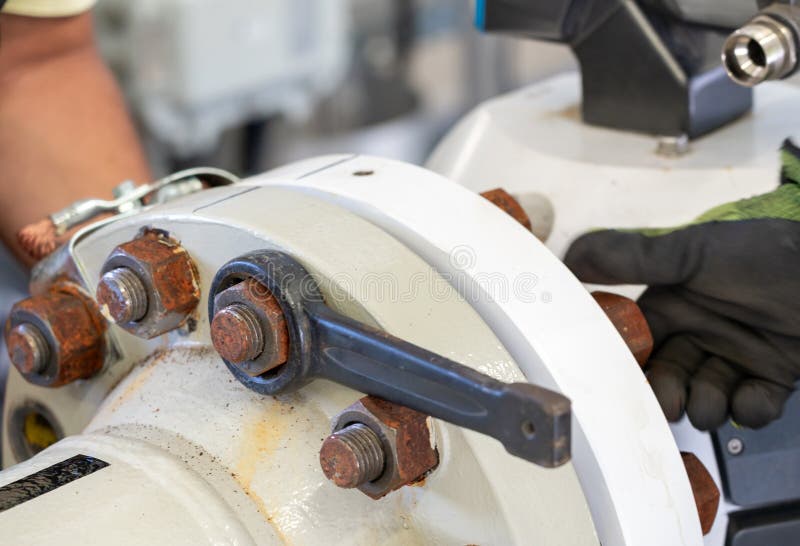 Removing Rusty Bolts from a Pipeline Flange Using a Wrench during ...