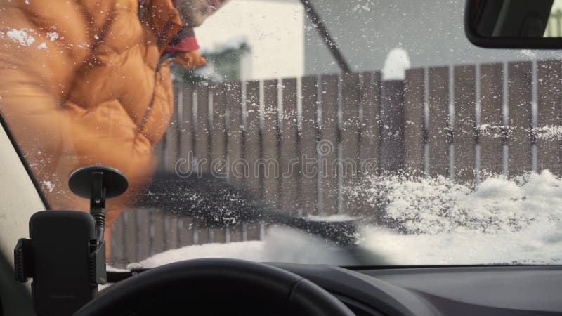 Removing Snow from a Car Windshield, View from Inside the Car. Stock ...