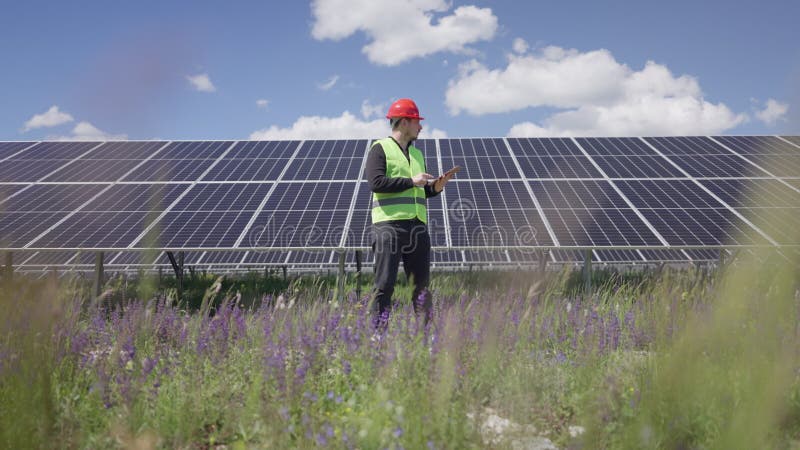 Renewable Energy Engineer Using Tablet in Front of the Solar Power ...