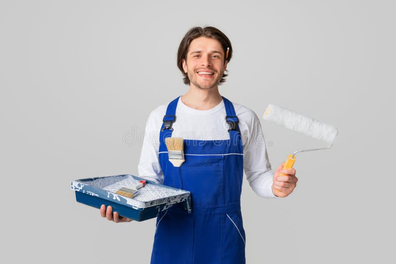 Renovation Services. Smiling Painter in Uniform with Painting Tools in ...