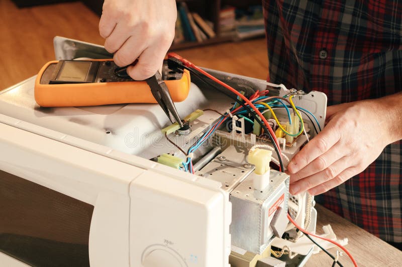 A Repair Engineer Disassembles a Microwave Oven Looking for a Fault ...