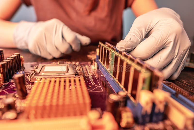 A Repair Engineer Holds a RAM Chip with His Hands, Inserts the RAM into ...