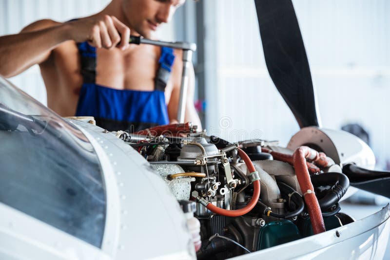 Repair Man in Overall Fixing Engine on a Plane Stock Image - Image of ...