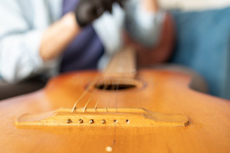 Repair of an Old Guitar. the Man Inserts the Strings into the Holes in ...