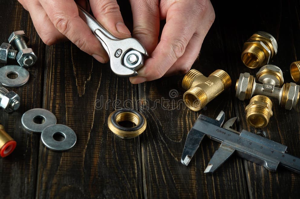 Repair of Plumbing Equipment on the Table in the Workshop by the Hands ...
