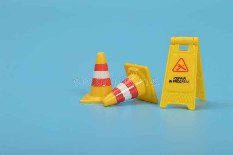 Repair in Progress Sign and Safety Plastic Cones Isolated on a Blue ...