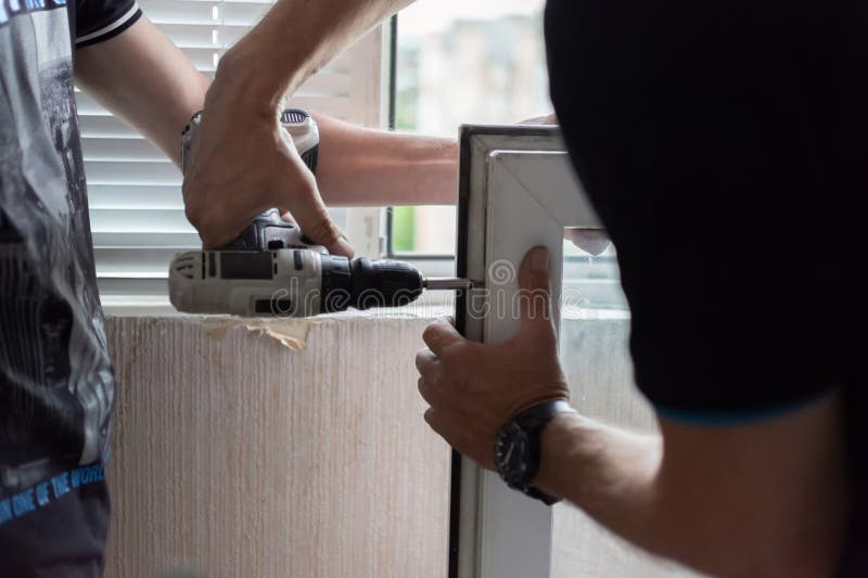 Repair of PVC Windows. a Worker Installs a New Pvc Window Mechanism ...