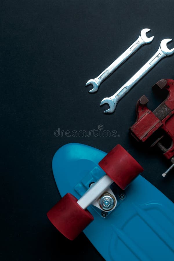 Repair Tools and Blue Skateboard with Red Wheels on a Gray Background ...