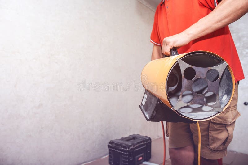 Repairers Stretch the Stretch Ceiling with a Gas Heat Gun. Worker ...