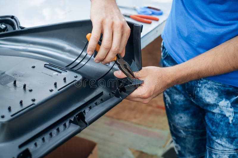 Repairing a Component: Hands Using Pliers To Fix a Black Plastic Part ...
