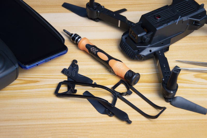 Repairing a Small Screwdriver Drone on the Table with Various Tools in ...