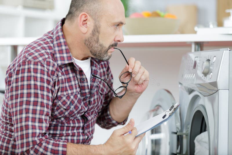 Repairman with Clipboard Looking at Machine Stock Photo - Image of ...